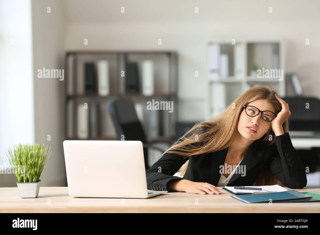 Stressed young woman at workplace Stock Photo - Alamy