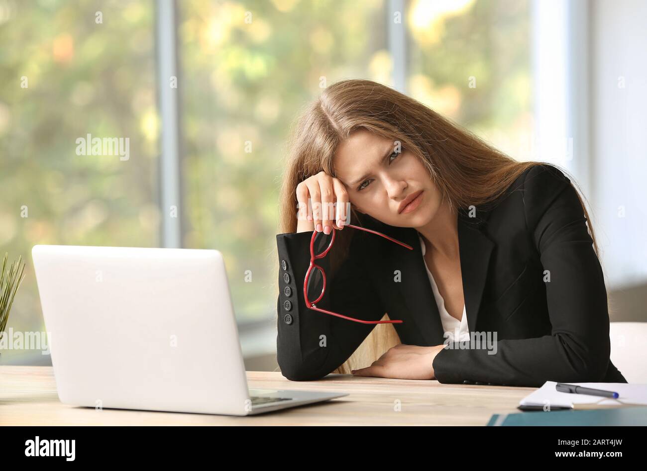 Stressed young woman at workplace Stock Photo - Alamy