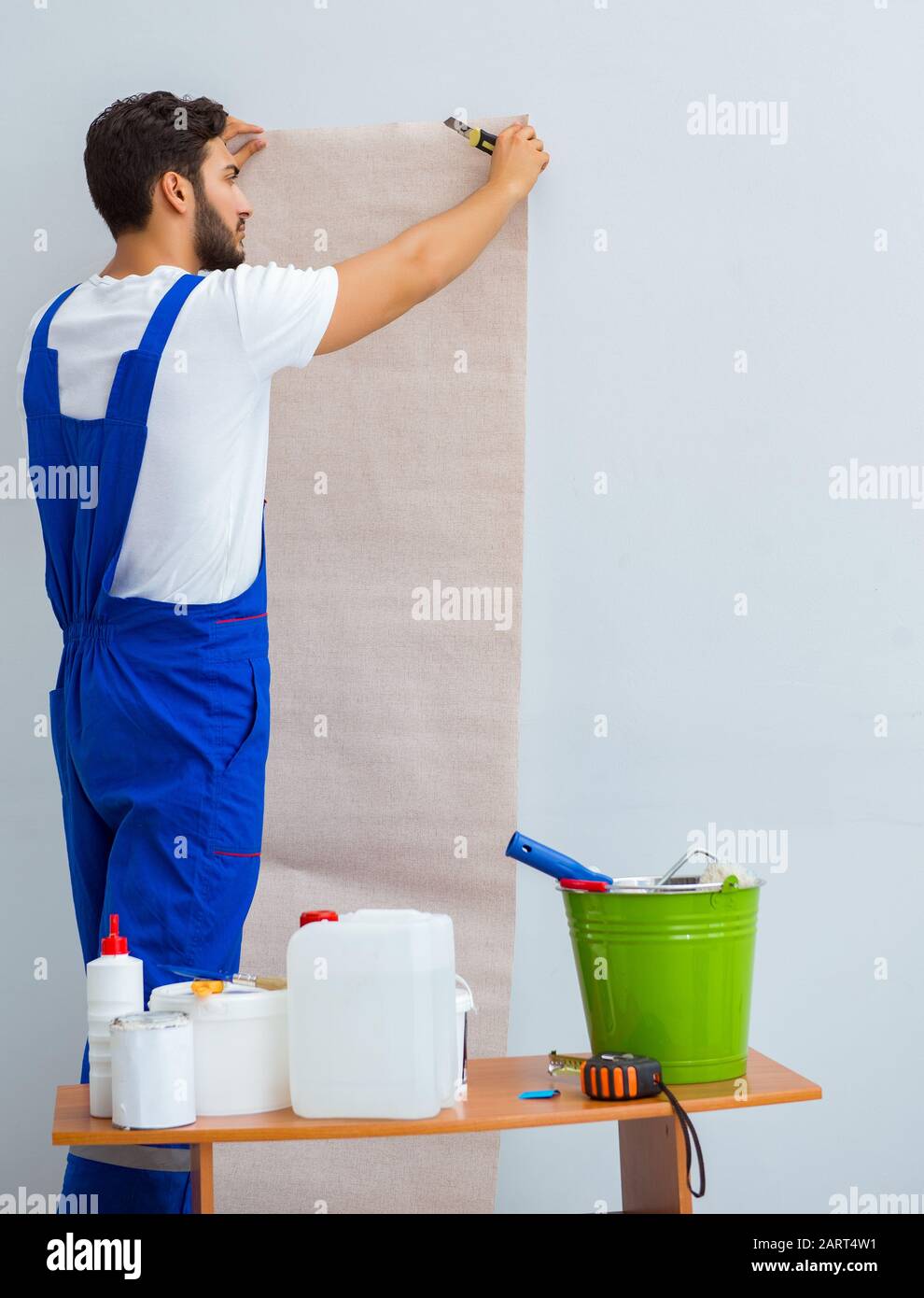 The worker working on wallpaper during refurbishment Stock Photo - Alamy