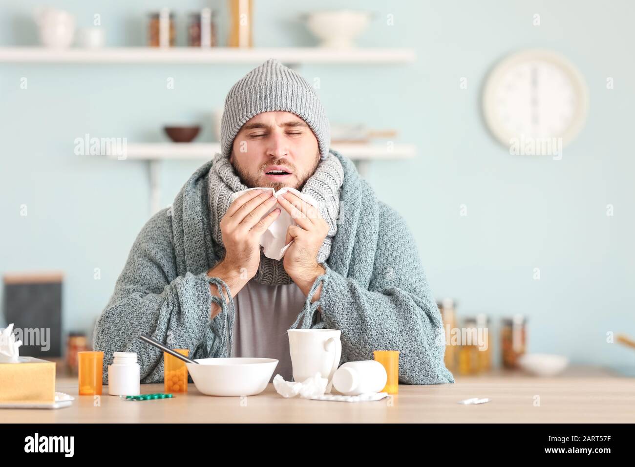 Sick man sitting at kitchen table Stock Photo - Alamy