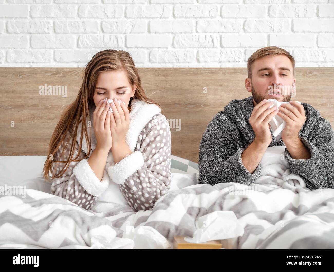 Sick young couple in bed at home Stock Photo - Alamy