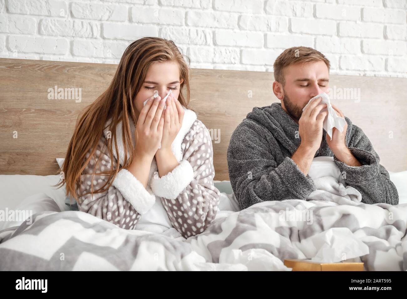 Sick young couple in bed at home Stock Photo - Alamy