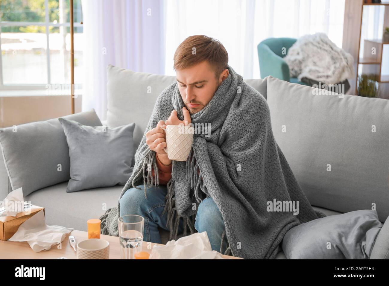 Sick man drinking hot tea at home Stock Photo - Alamy