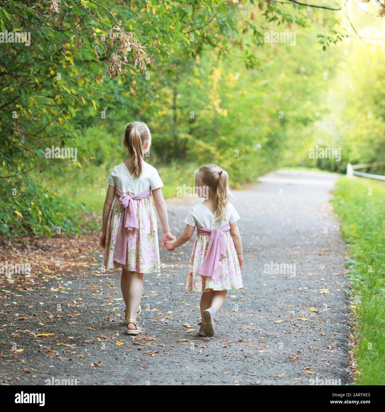 Two cute blonde sisters in the same dress, selective focus Stock Photo ...
