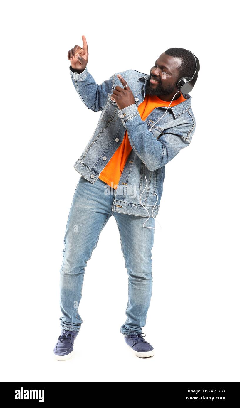 Handsome African-American man listening to music on white background ...