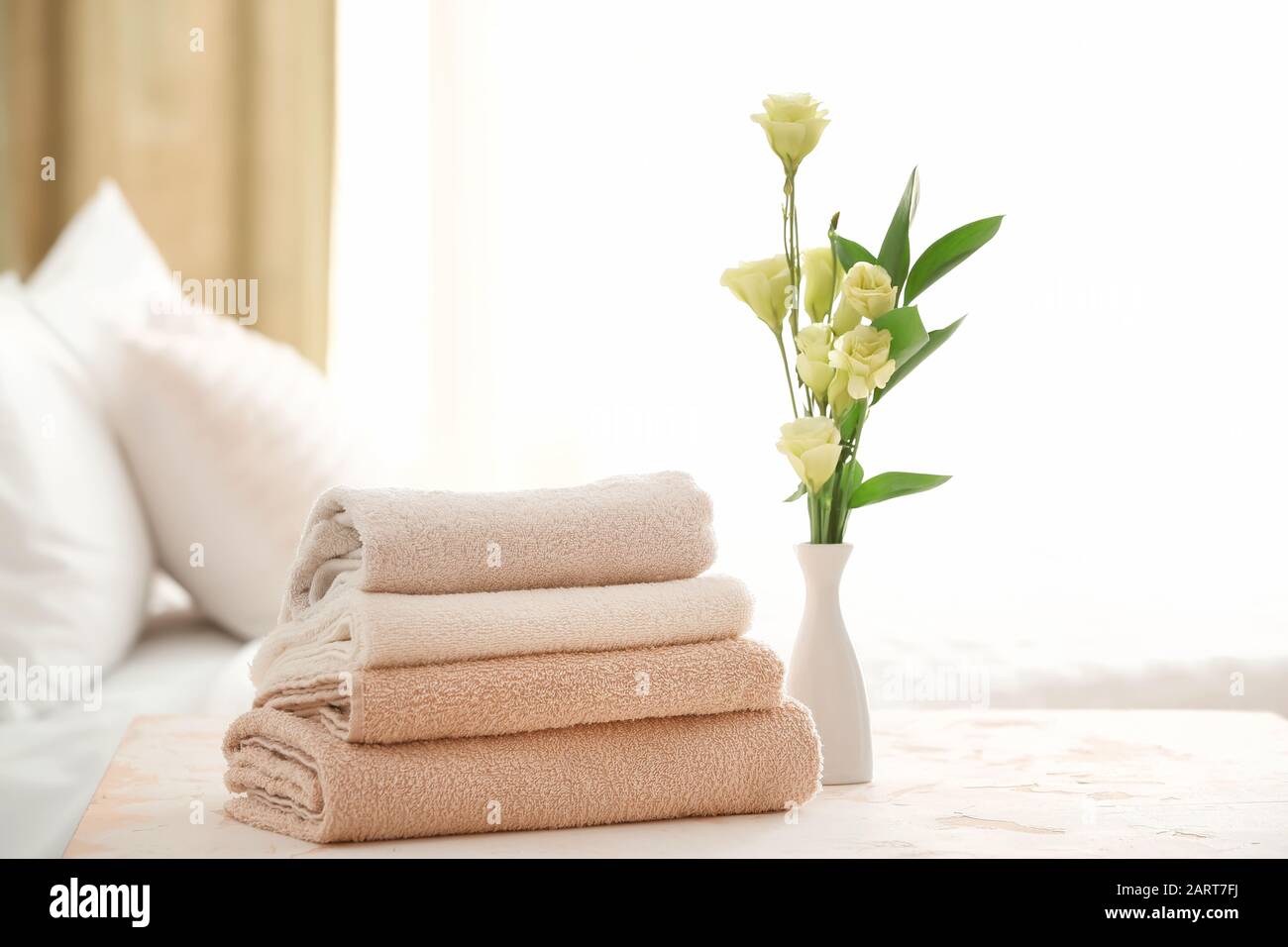 Stack of clean towels on table in bedroom Stock Photo - Alamy
