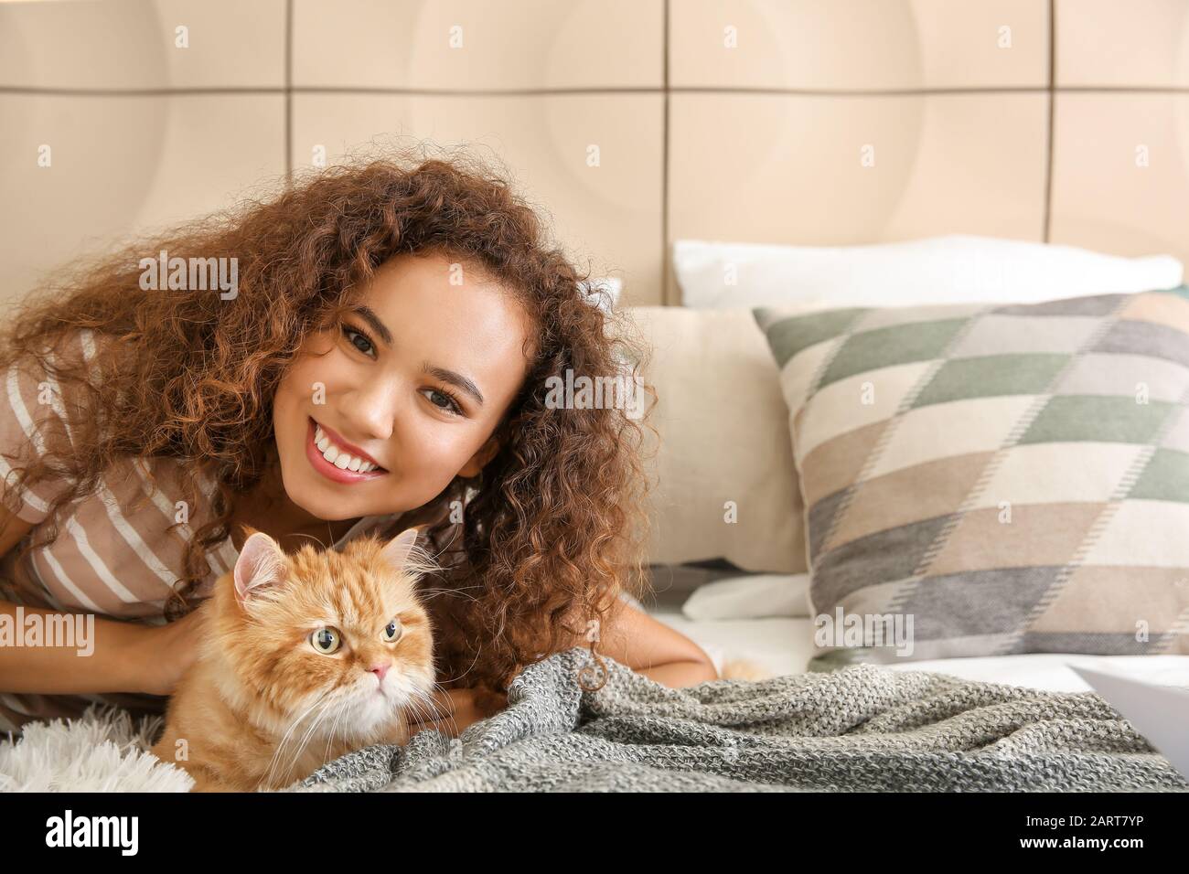 Young African-American woman with cute cat at home Stock Photo - Alamy