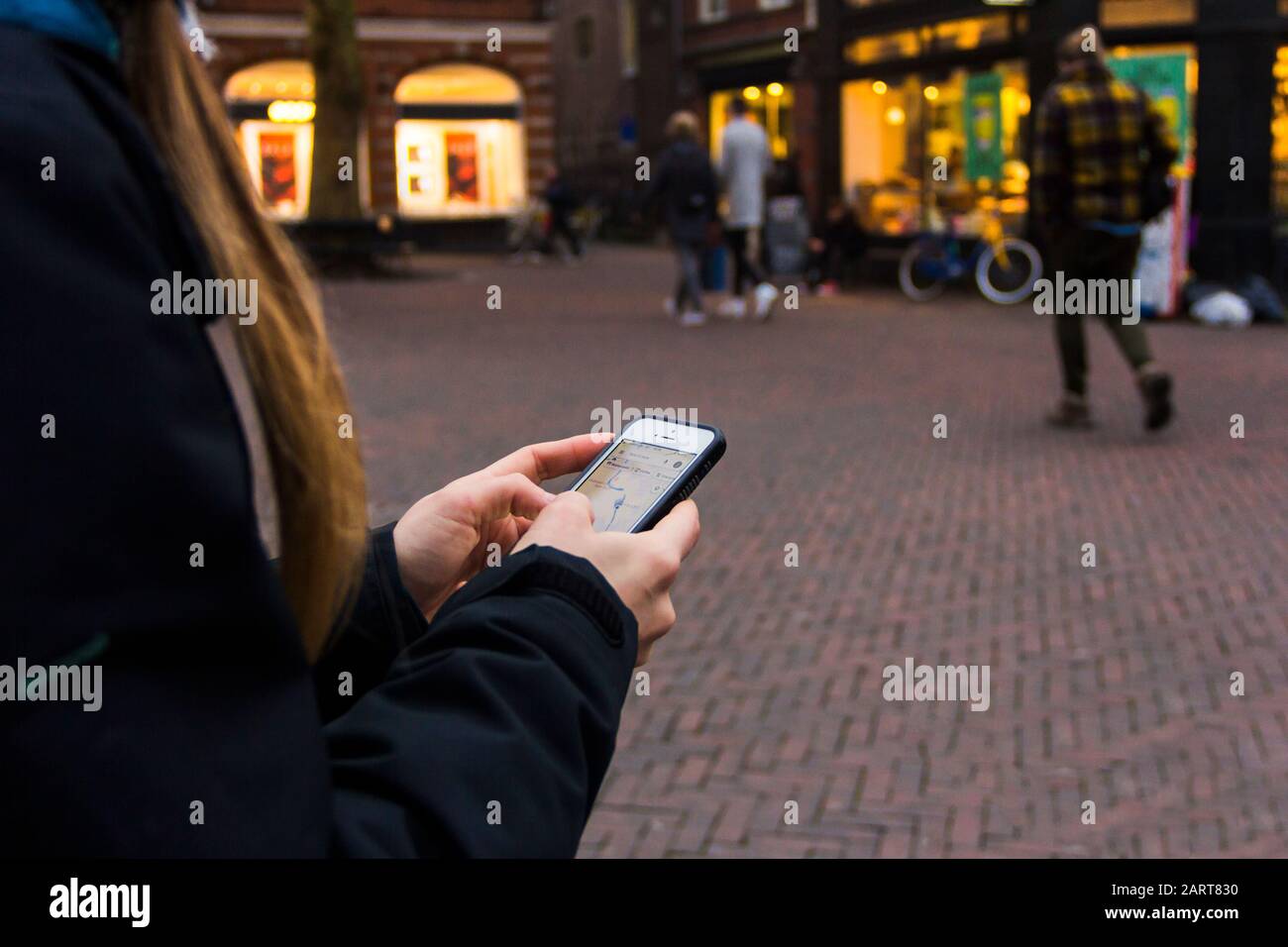 Tourist girl using navigation app on a smart phone making search on a ...