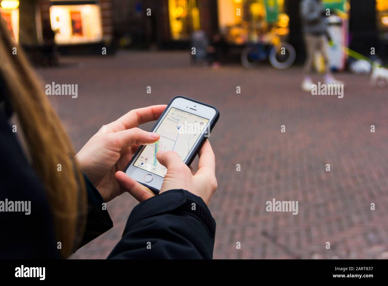 Tourist girl using navigation app on a smart phone making search on a ...