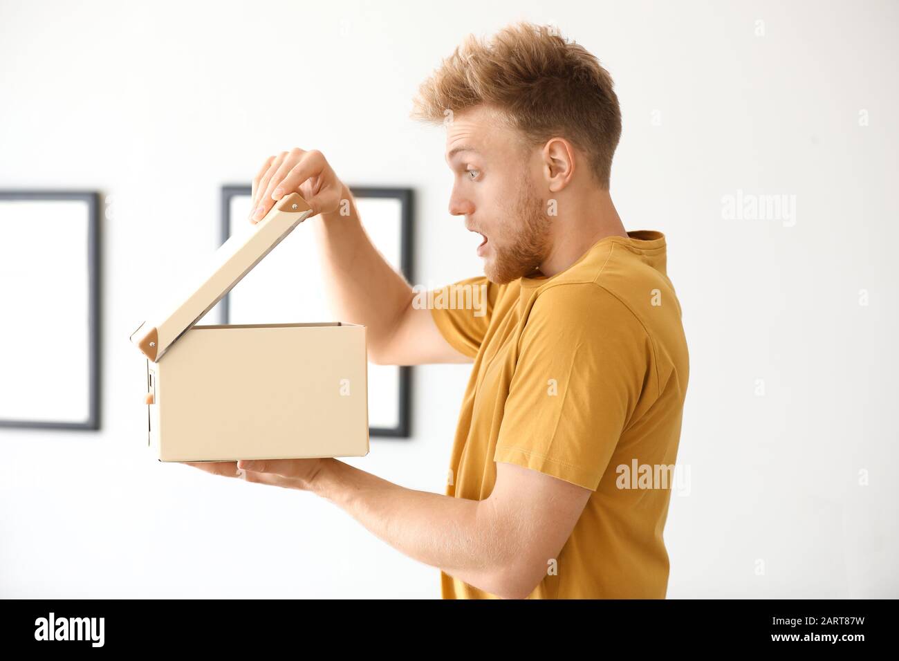Portrait of shocked man opening box at home Stock Photo - Alamy