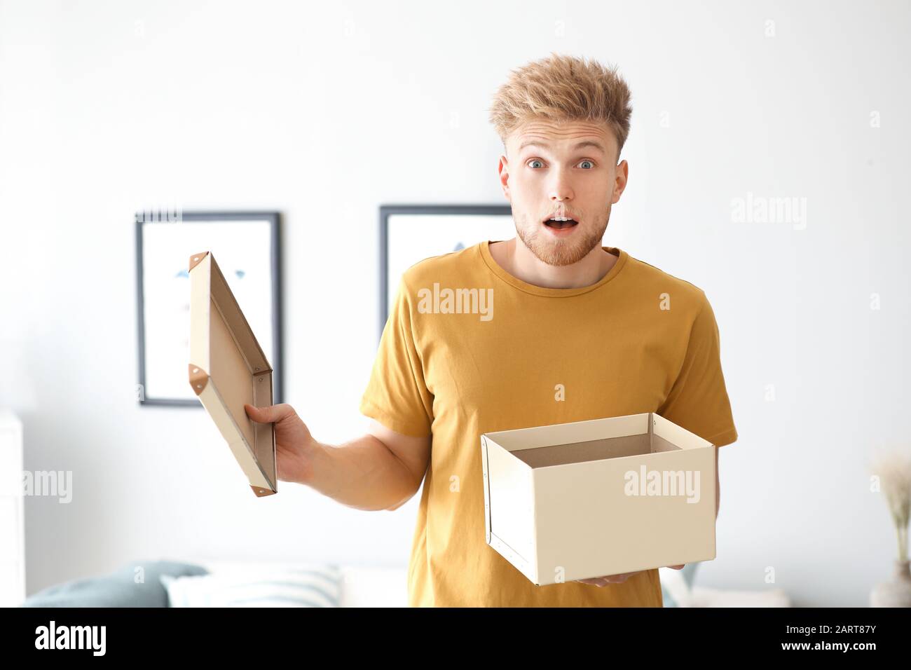 Portrait of shocked man opening box at home Stock Photo - Alamy