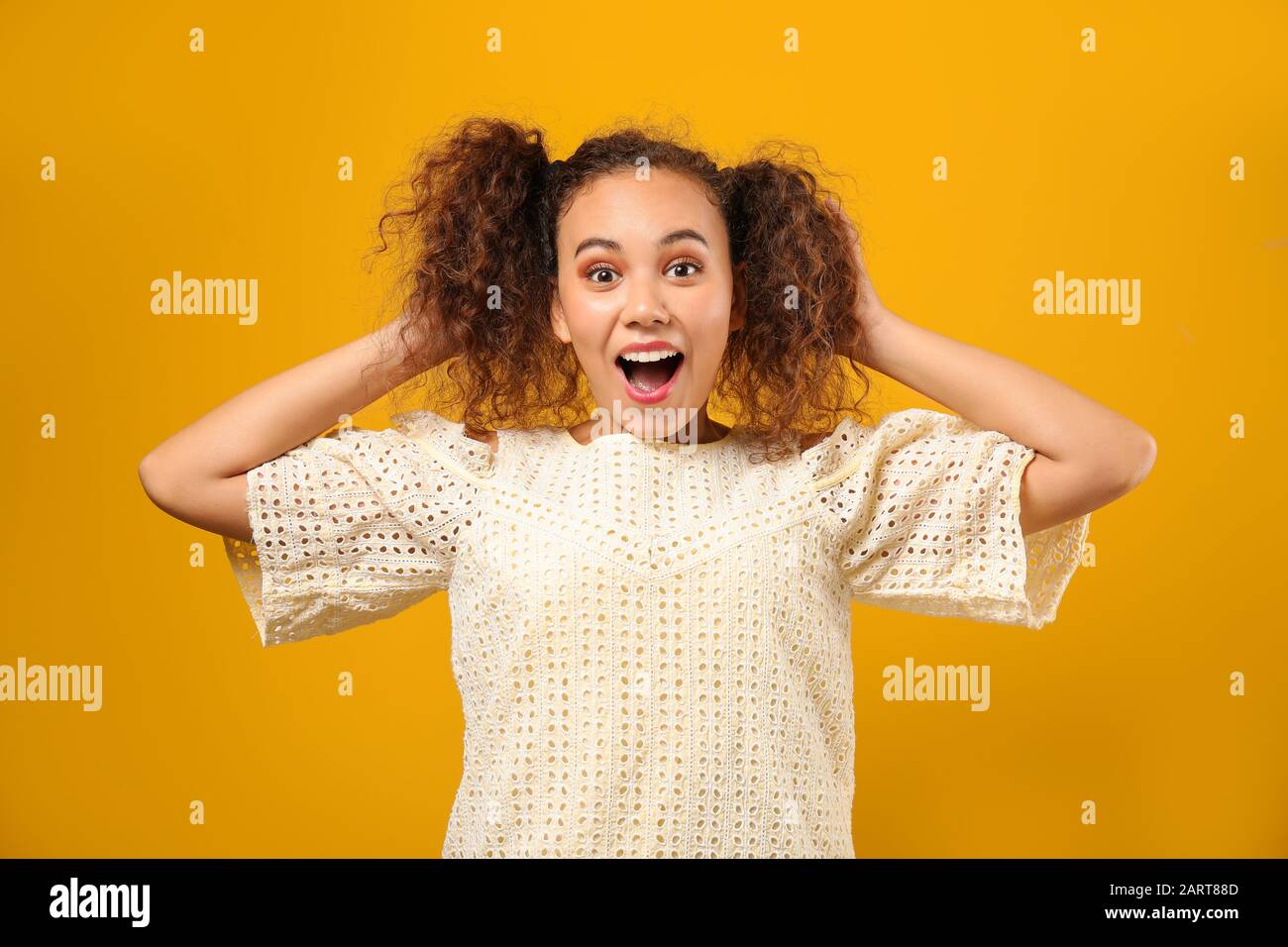 Portrait of surprised African-American woman on color background Stock ...