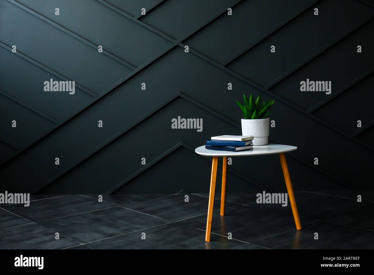 Small table near dark wall Stock Photo - Alamy