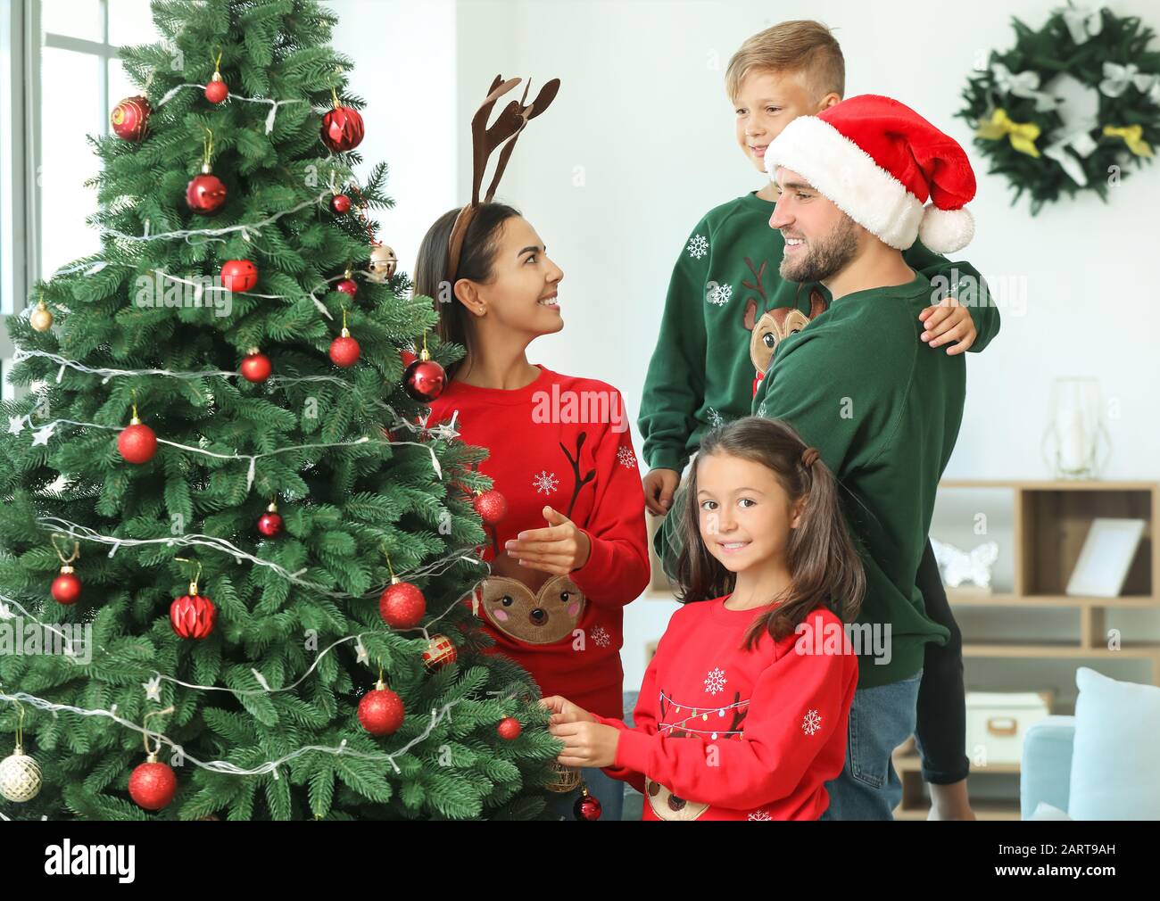 Happy family decorating Christmas tree at home Stock Photo - Alamy