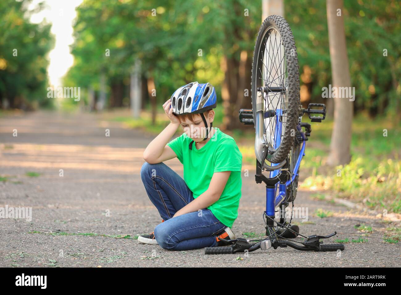 Sad boy with damaged bicycle outdoors Stock Photo - Alamy