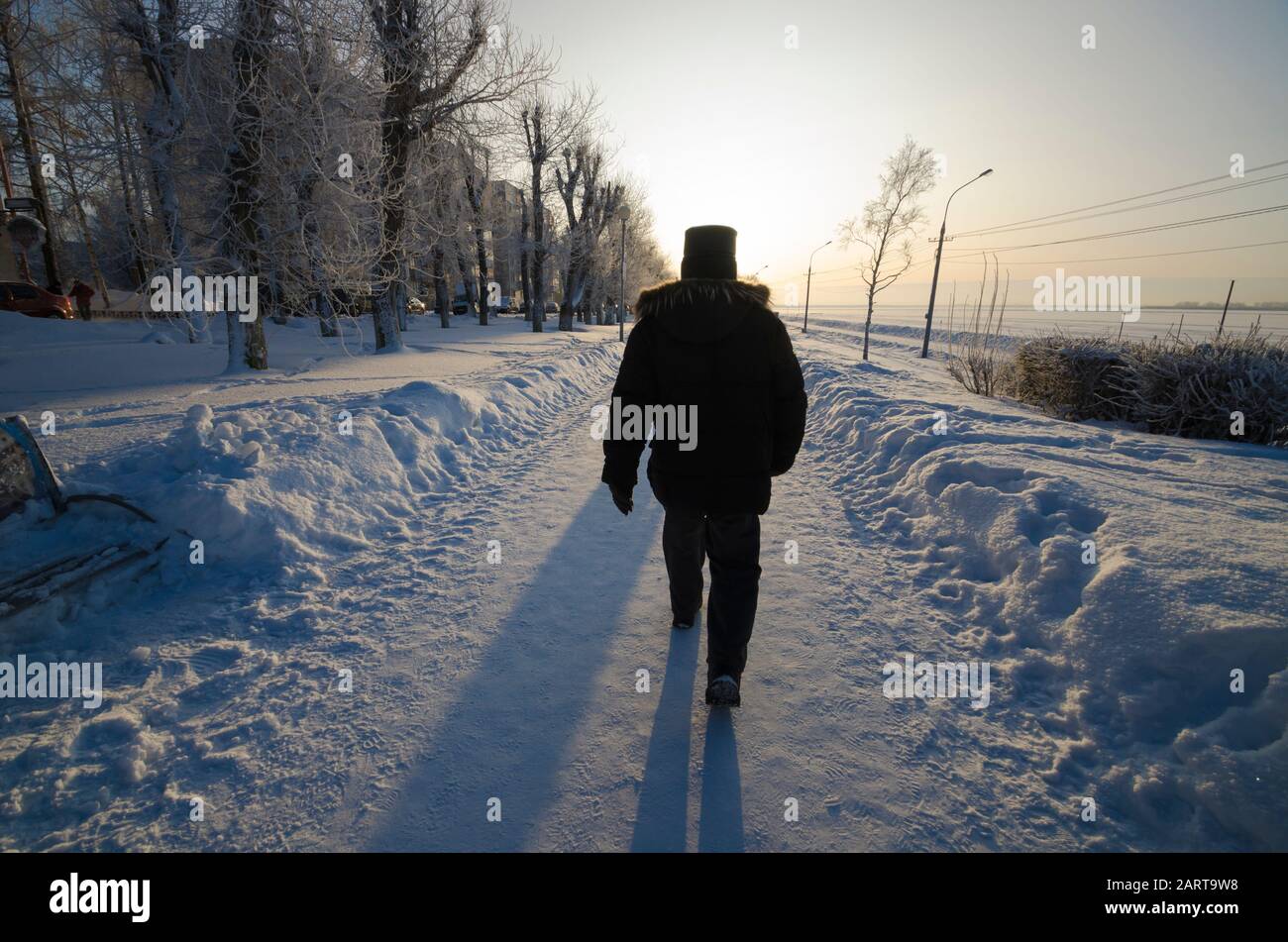 Walk on a frosty afternoon. Man walking on a snowy track Stock Photo ...