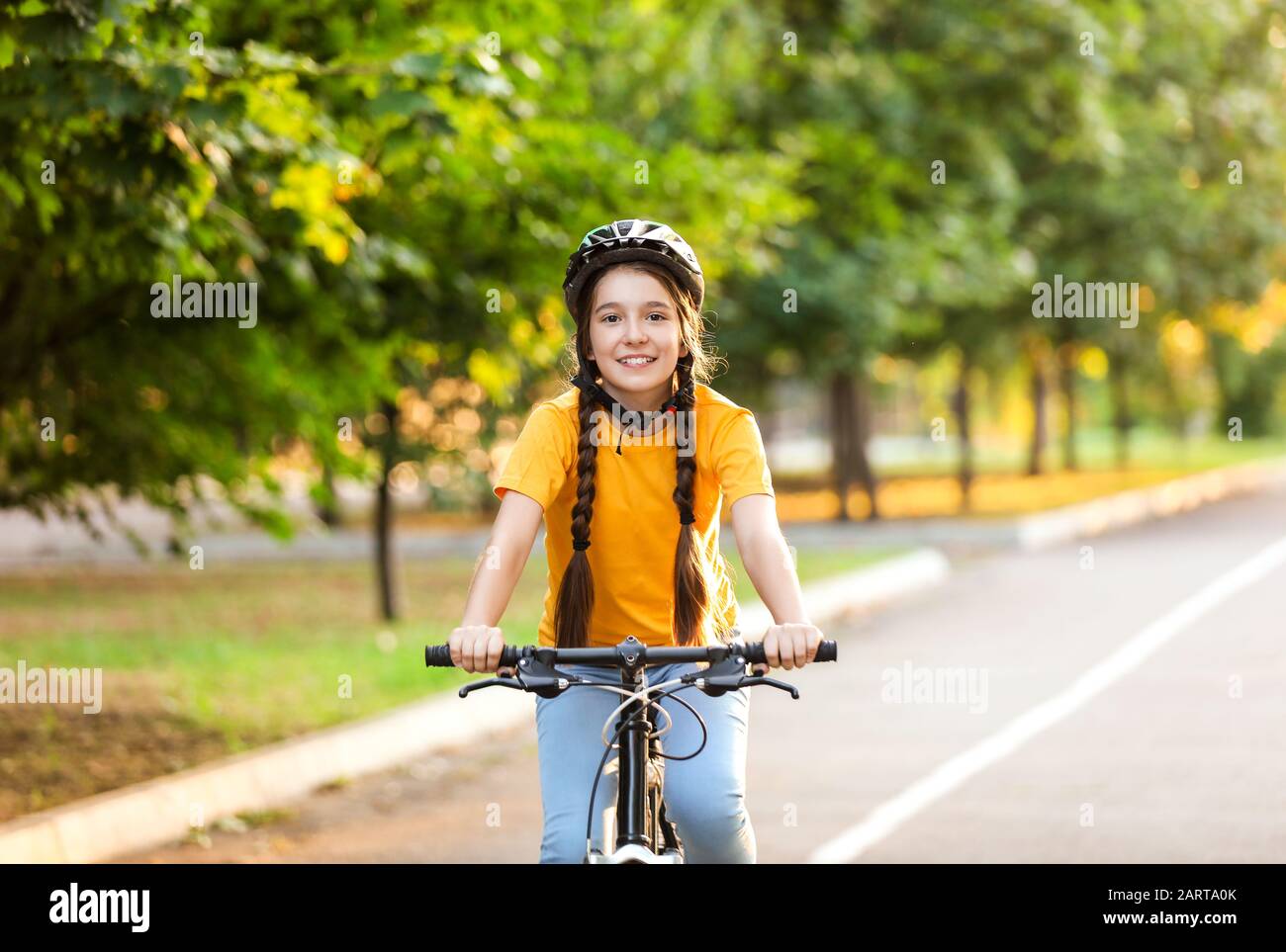 Cute girl riding bicycle outdoors Stock Photo - Alamy