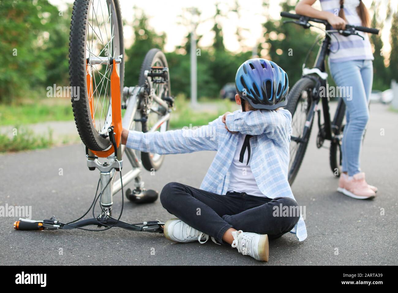 Sad boy sitting near damaged bicycle outdoors Stock Photo - Alamy