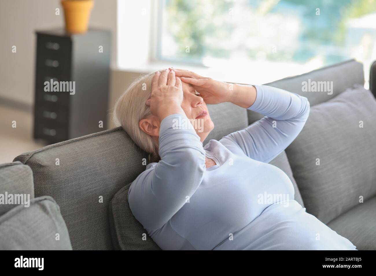 Mature woman suffering from headache at home Stock Photo - Alamy