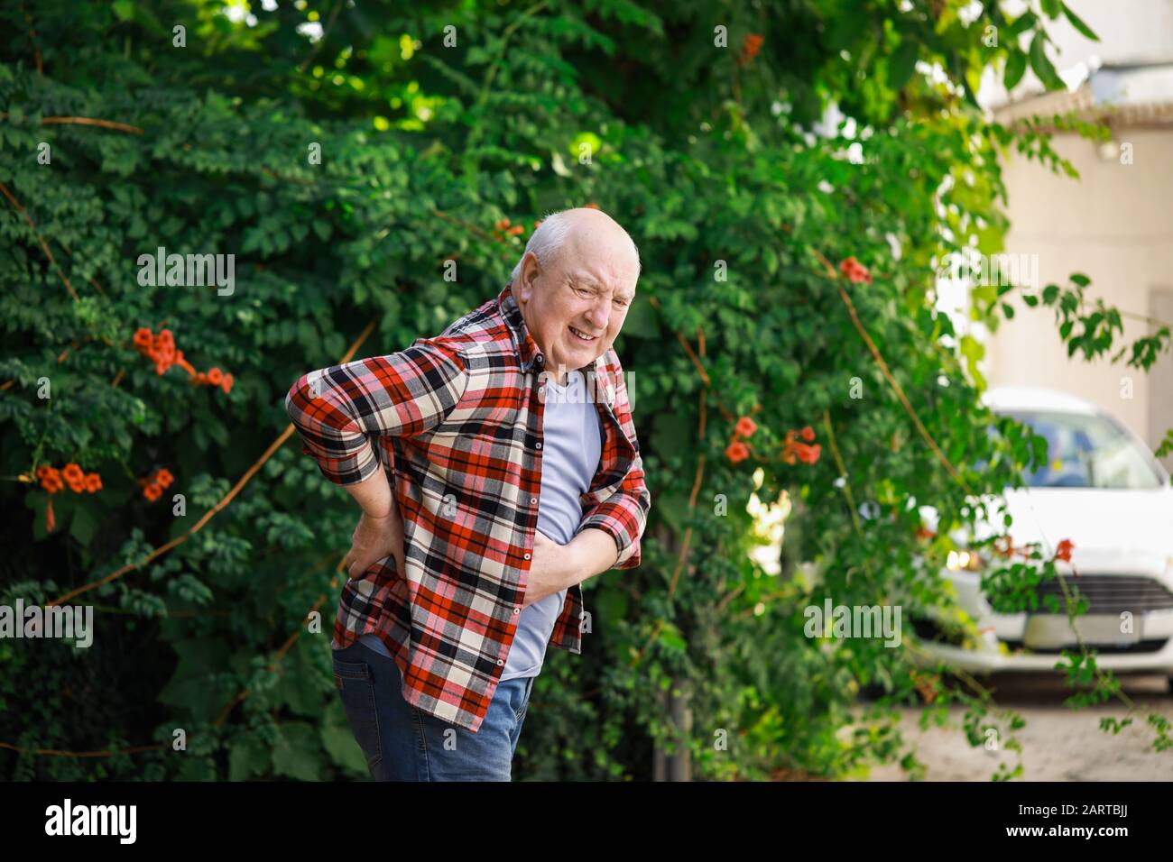 Senior man suffering from back pain outdoors Stock Photo - Alamy