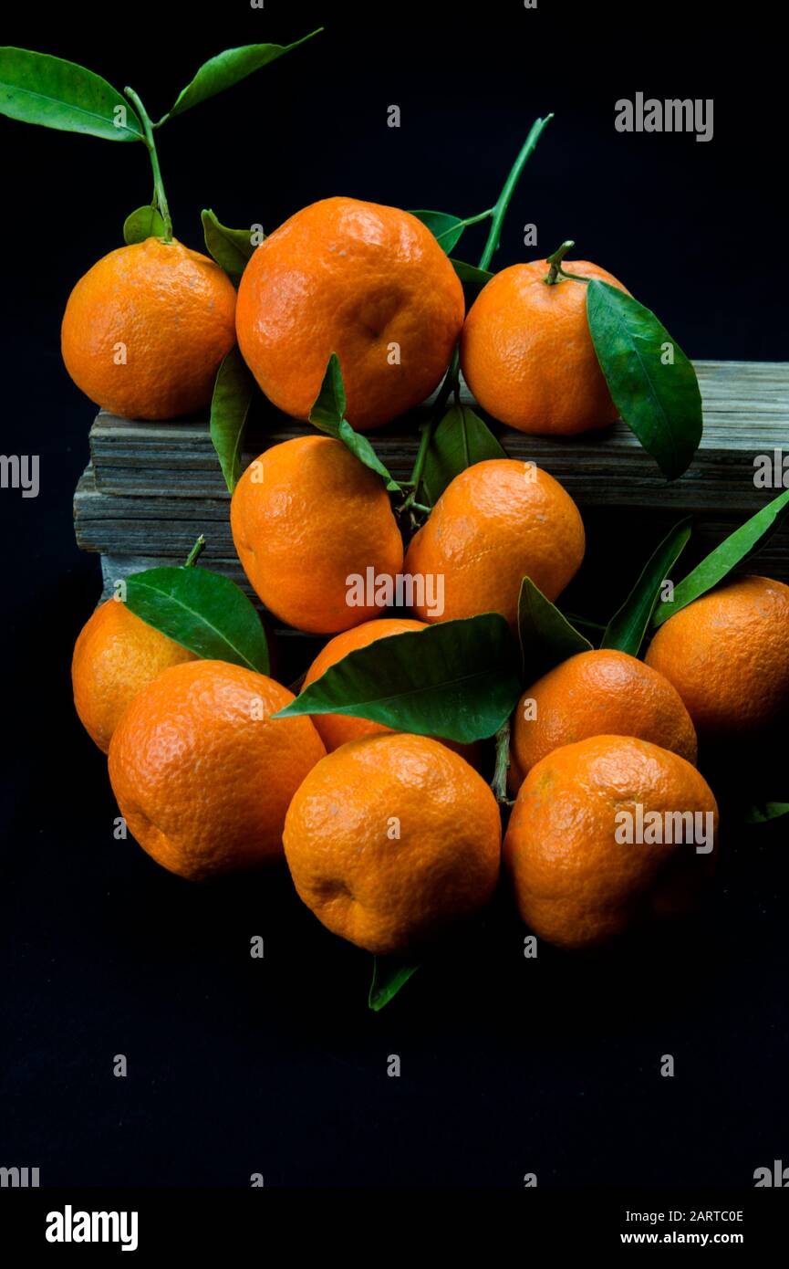 organic tangerines with leaves on black background Stock Photo - Alamy