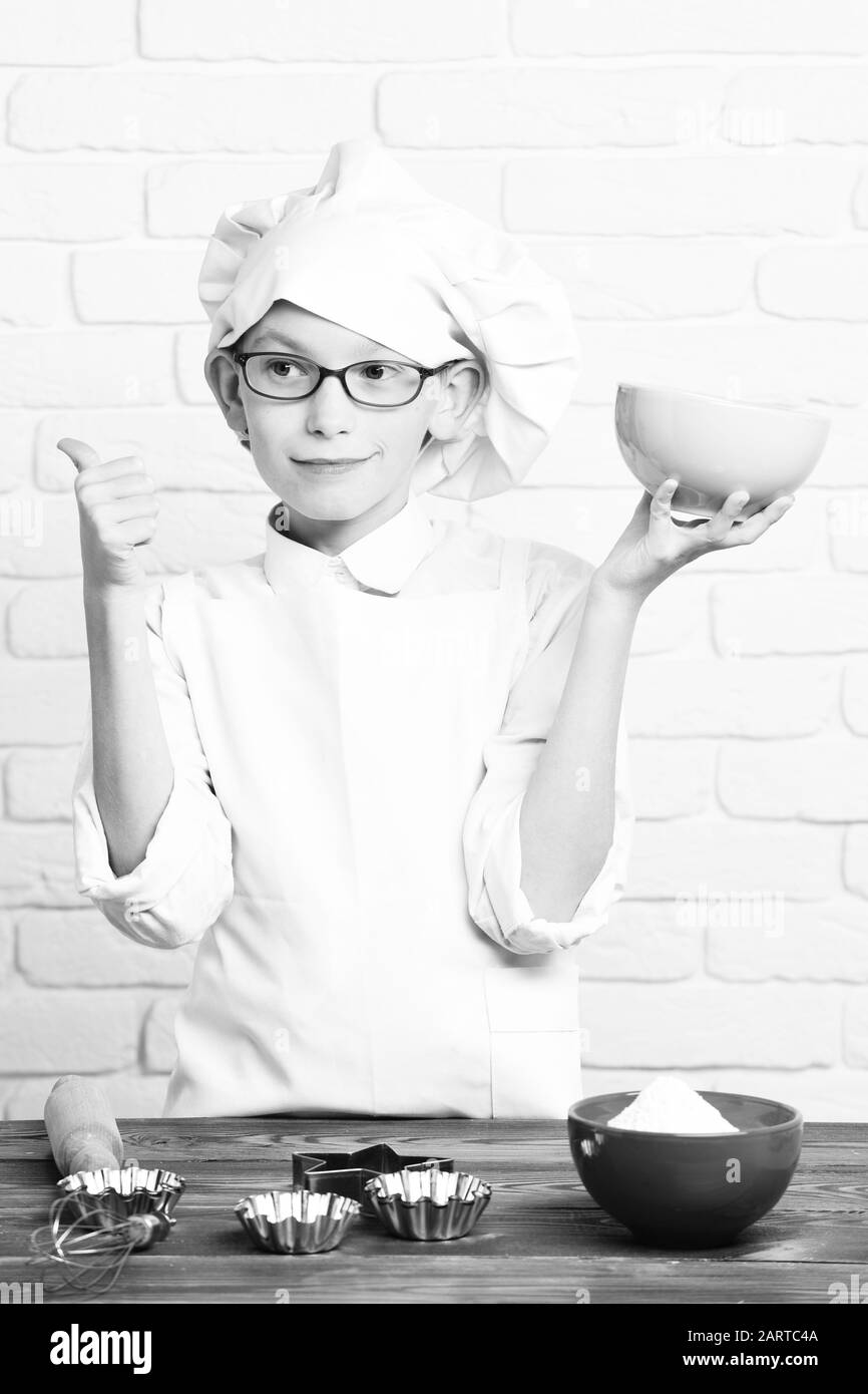 young boy small cute cook chef in white uniform and hat on smiling face ...