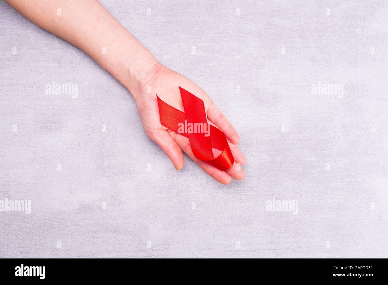 Aids red ribbon on woman's hand support for World aids day and national ...