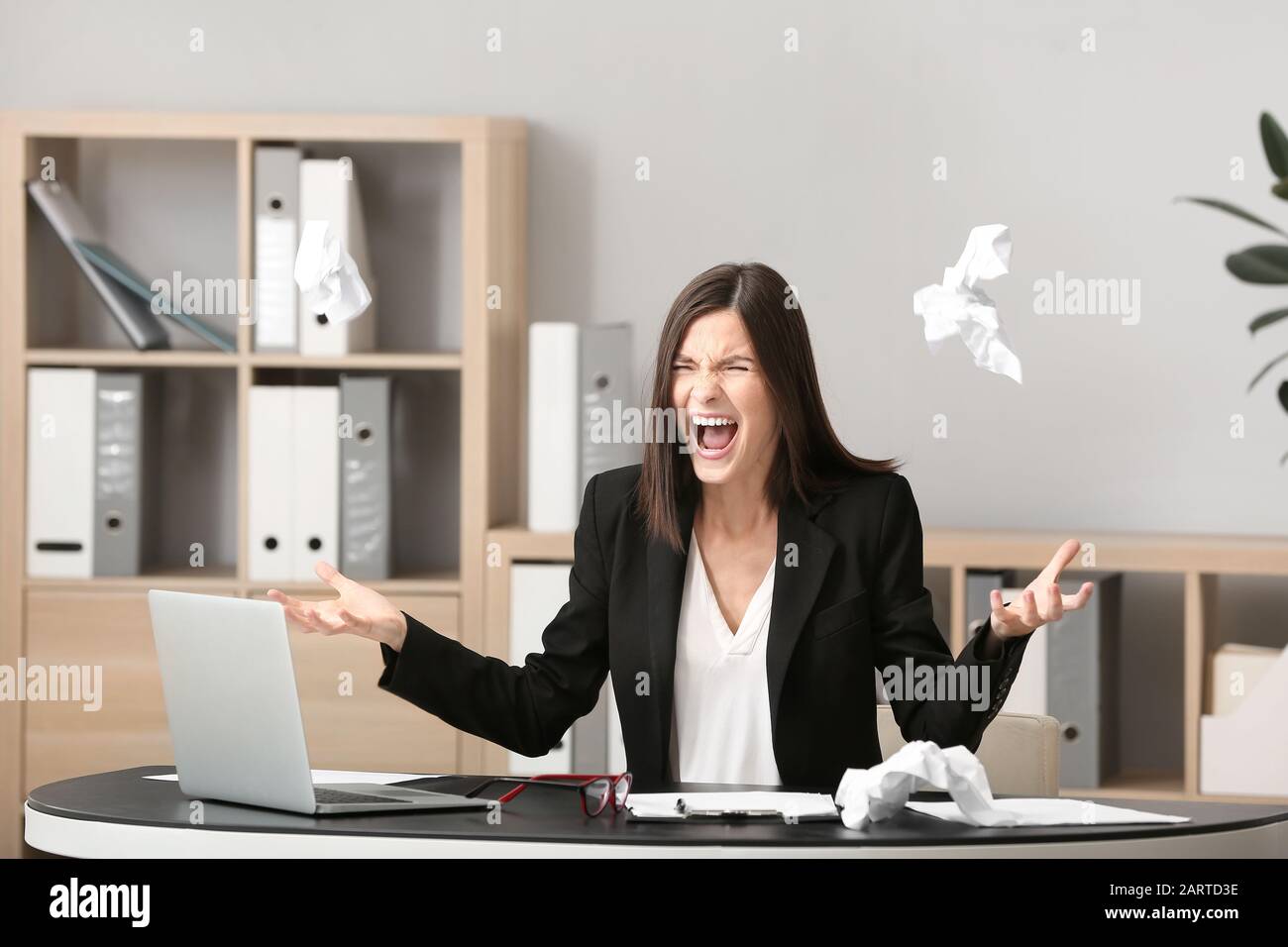Stressed young woman at workplace in office Stock Photo - Alamy