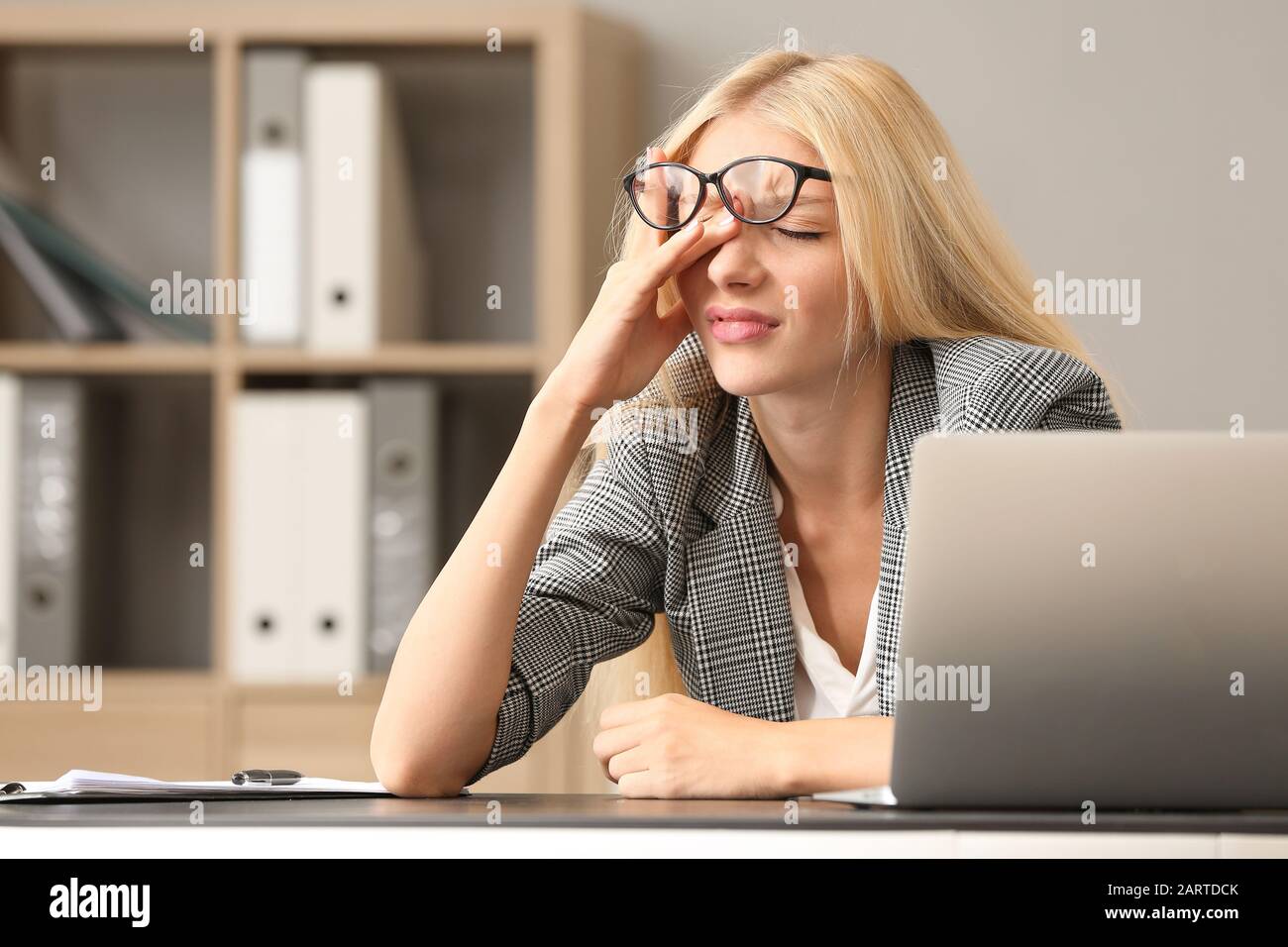Stressed young woman at workplace in office Stock Photo - Alamy