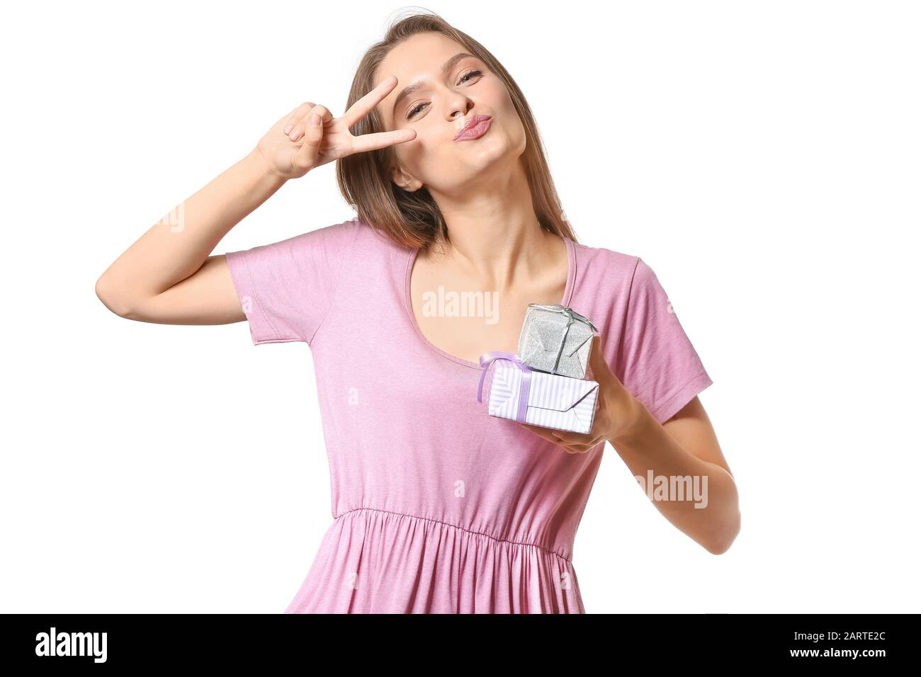Beautiful woman with gift boxes showing victory gesture on white ...