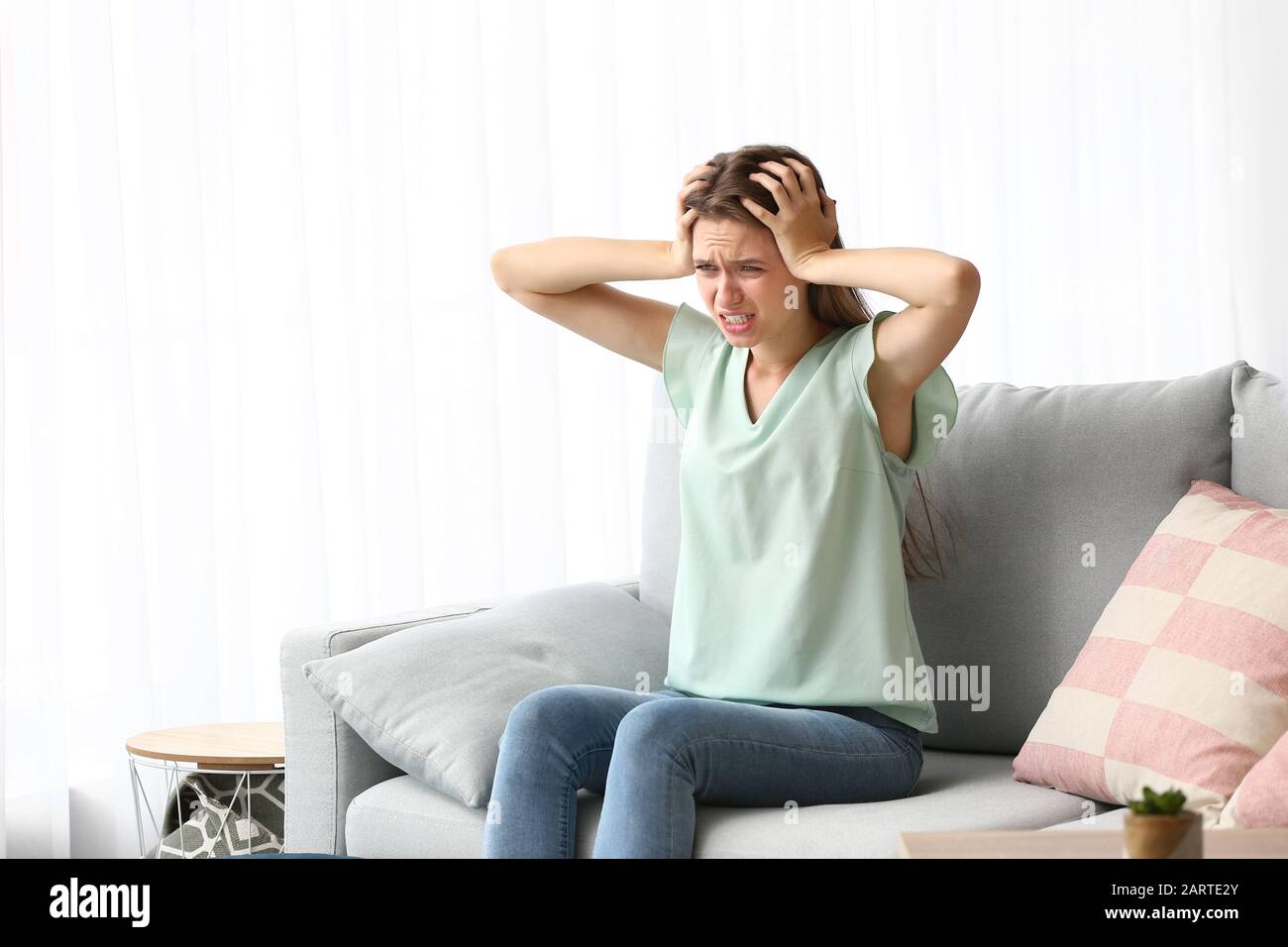 Stressed young woman at home Stock Photo - Alamy