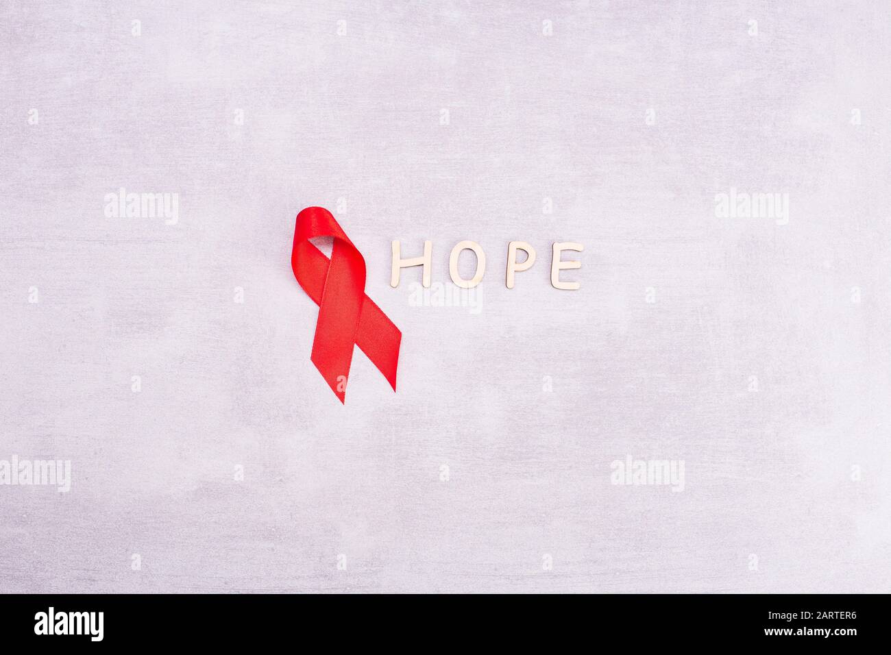 Red AIDS ribbon on a gray background and the words HOPE - support for ...