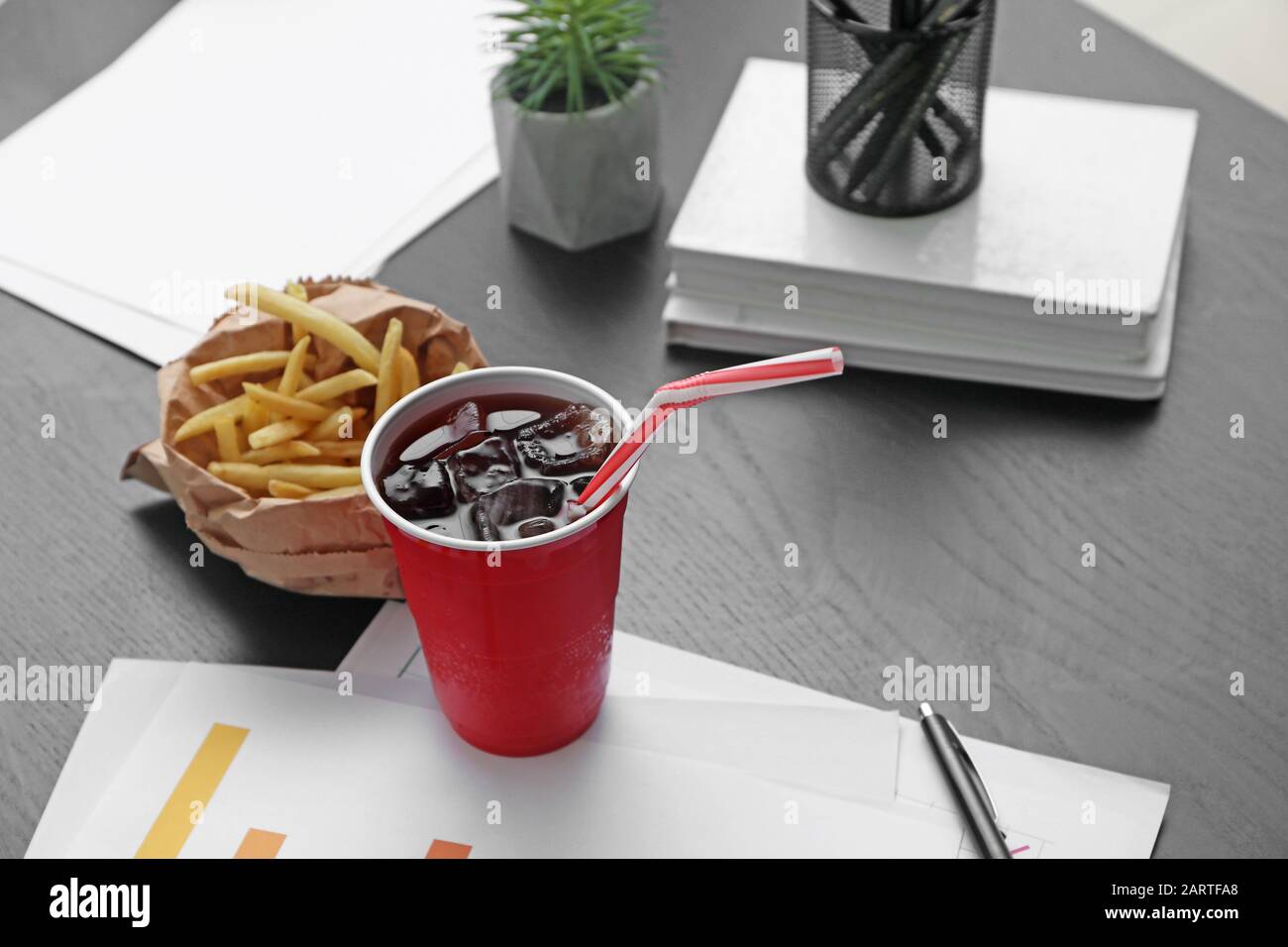 Cup of cold cola with french fries on table in office Stock Photo - Alamy