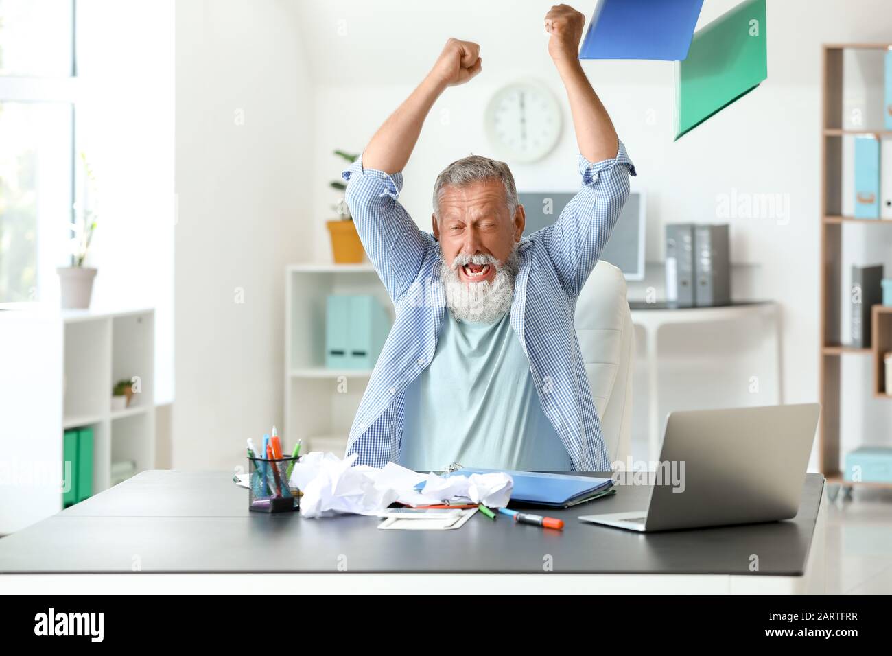 Angry mature man working in office Stock Photo - Alamy