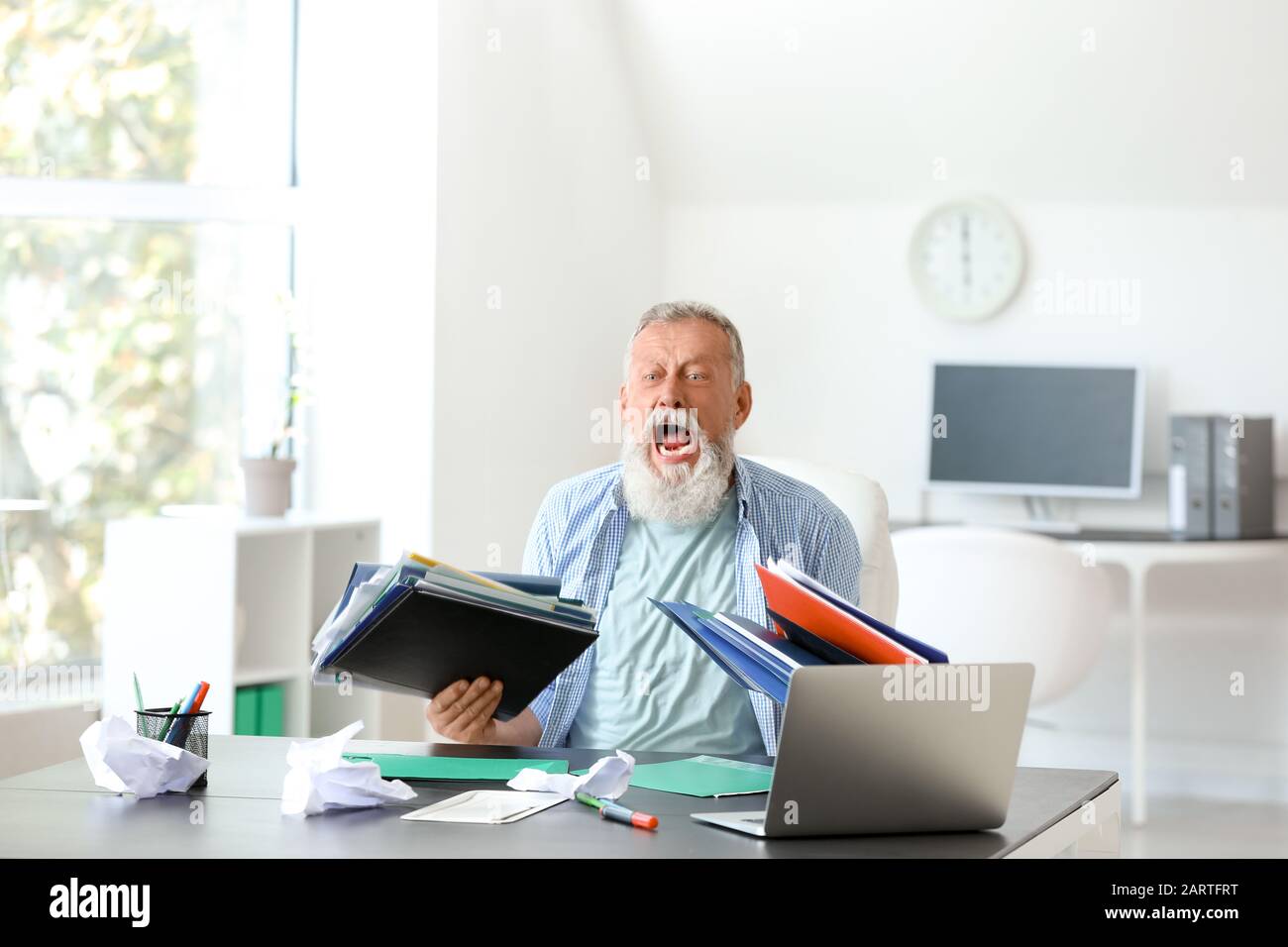Angry mature man working in office Stock Photo - Alamy