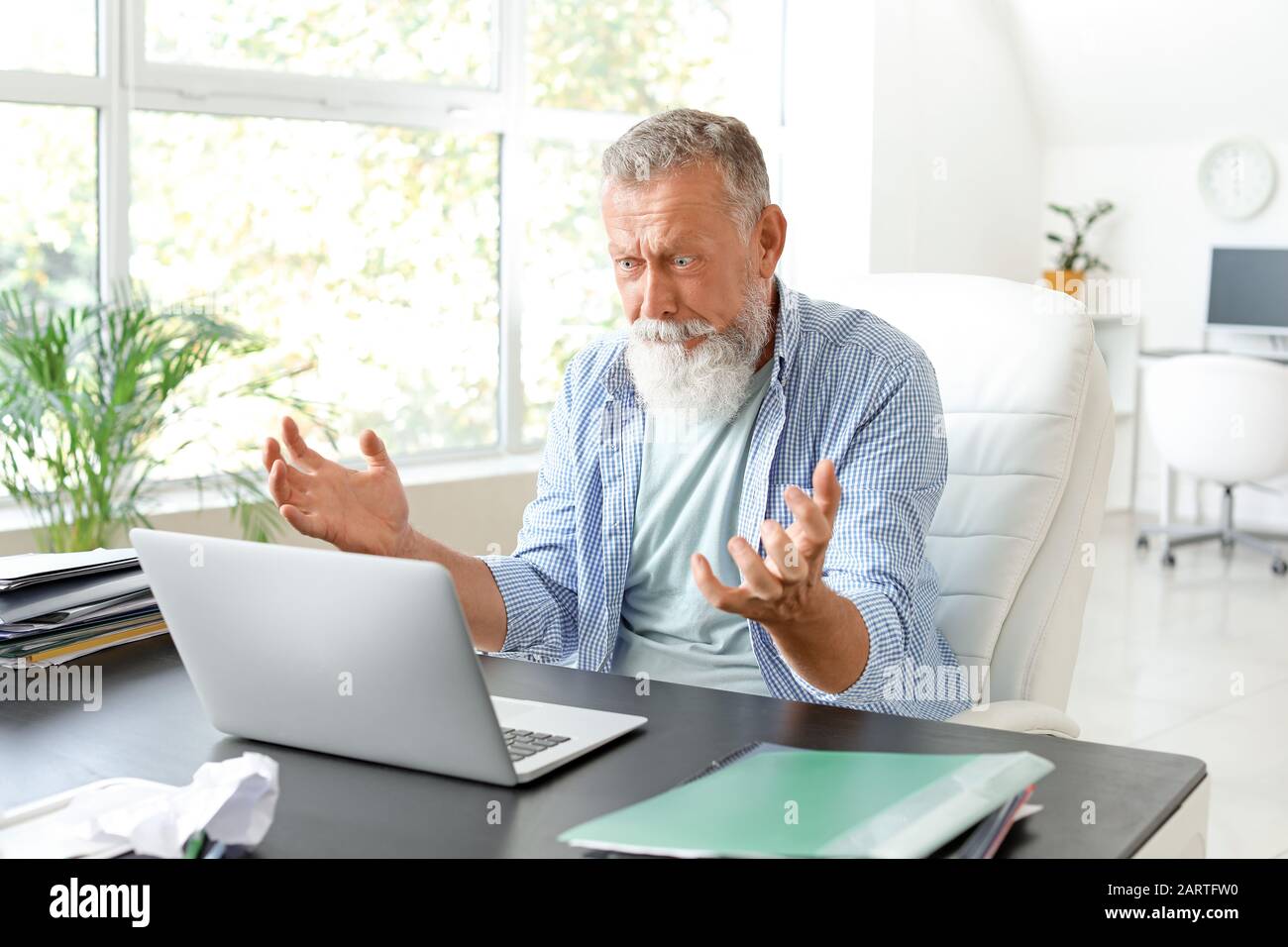 Angry mature man with laptop working in office Stock Photo - Alamy