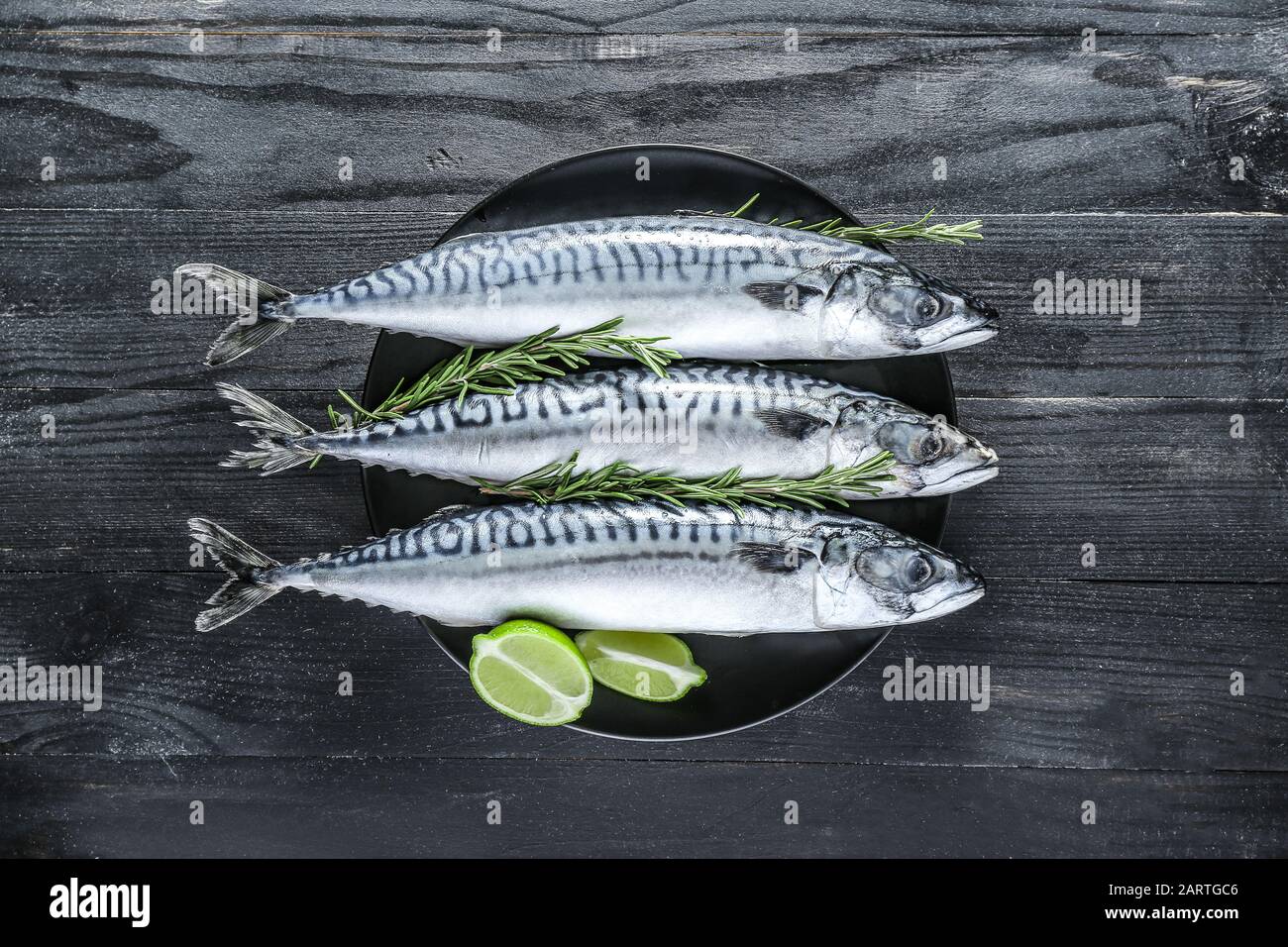 Plate with raw mackerel fish on dark table Stock Photo - Alamy