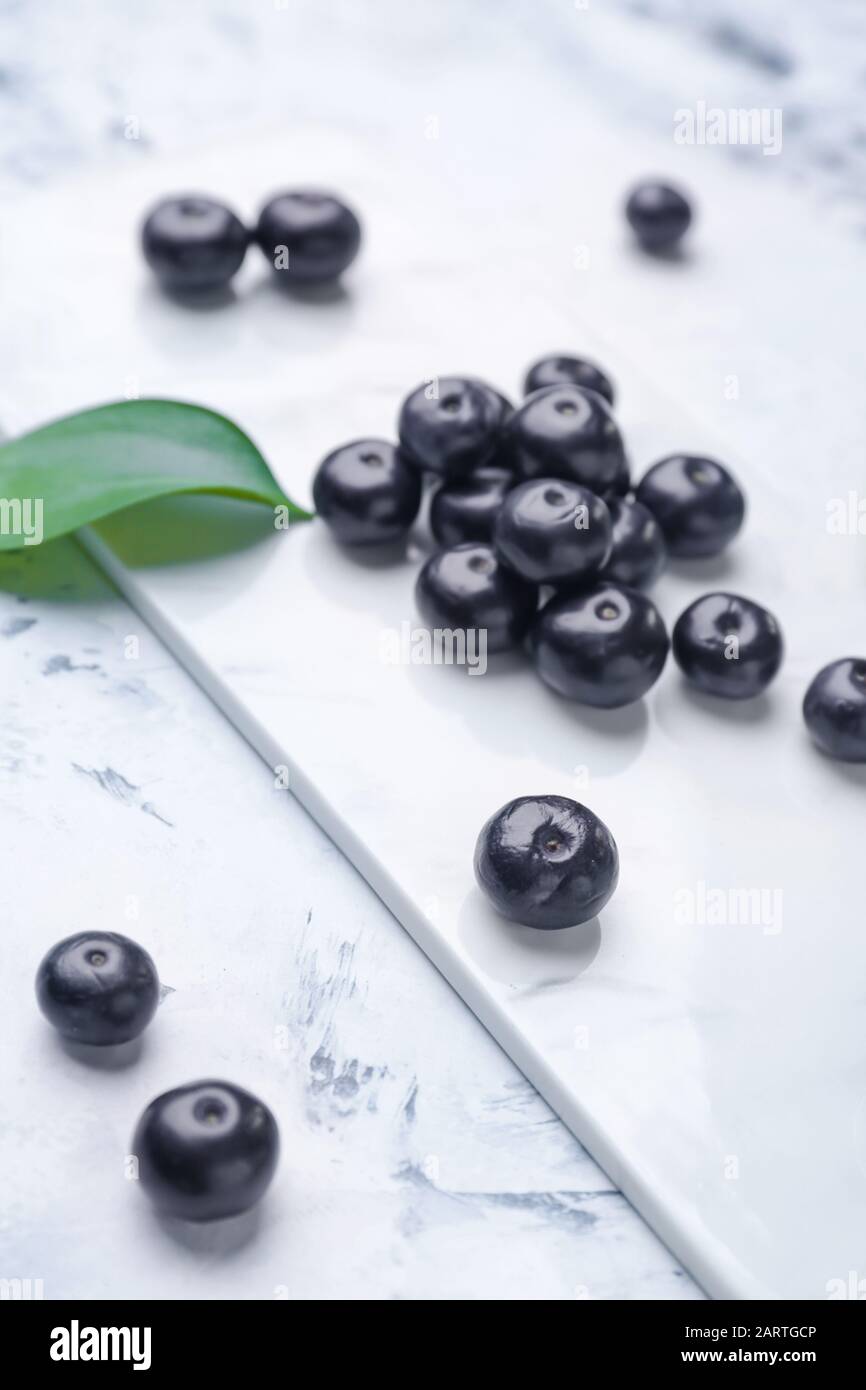 Fresh acai berries on white background Stock Photo - Alamy