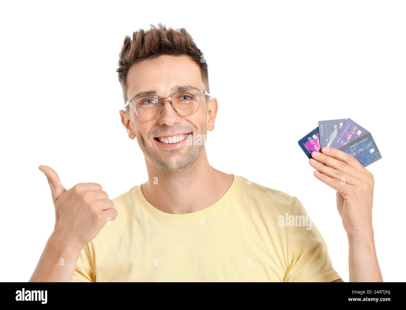 Young man with credit cards showing thumb-up gesture on white ...