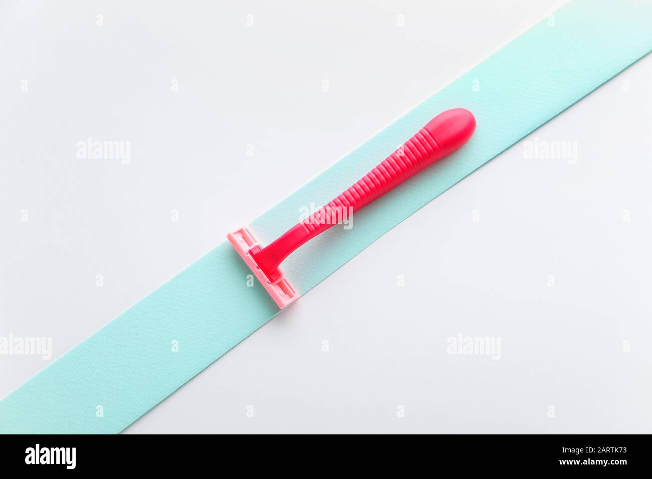 Razor and paper strip on light background Stock Photo - Alamy