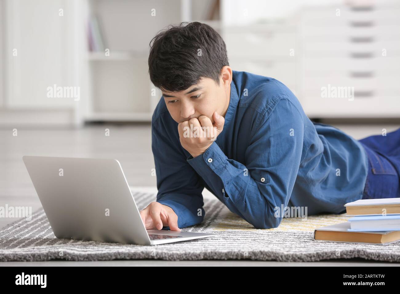 Asian student with laptop preparing for exam at home Stock Photo - Alamy