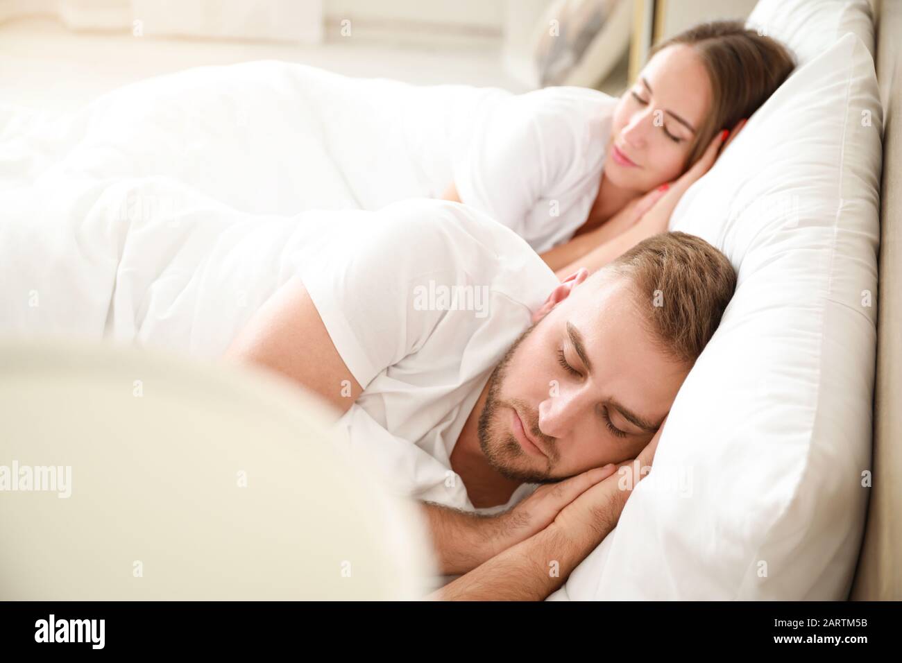 Morning of young couple sleeping in bed Stock Photo - Alamy