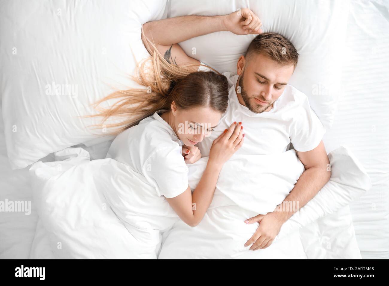 Morning of young couple sleeping in bed Stock Photo - Alamy
