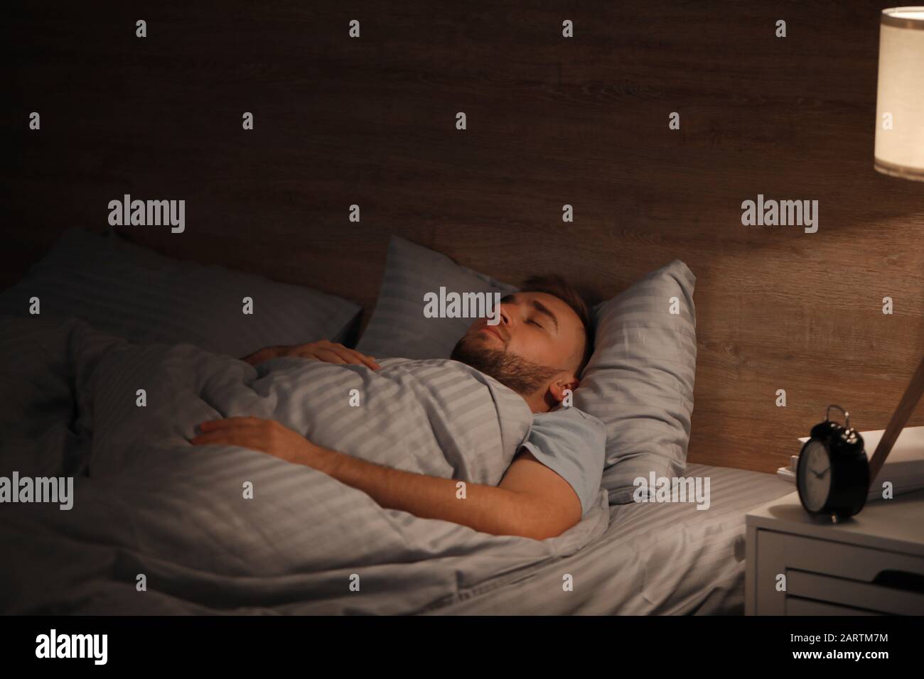 Young man sleeping in bed at night Stock Photo - Alamy