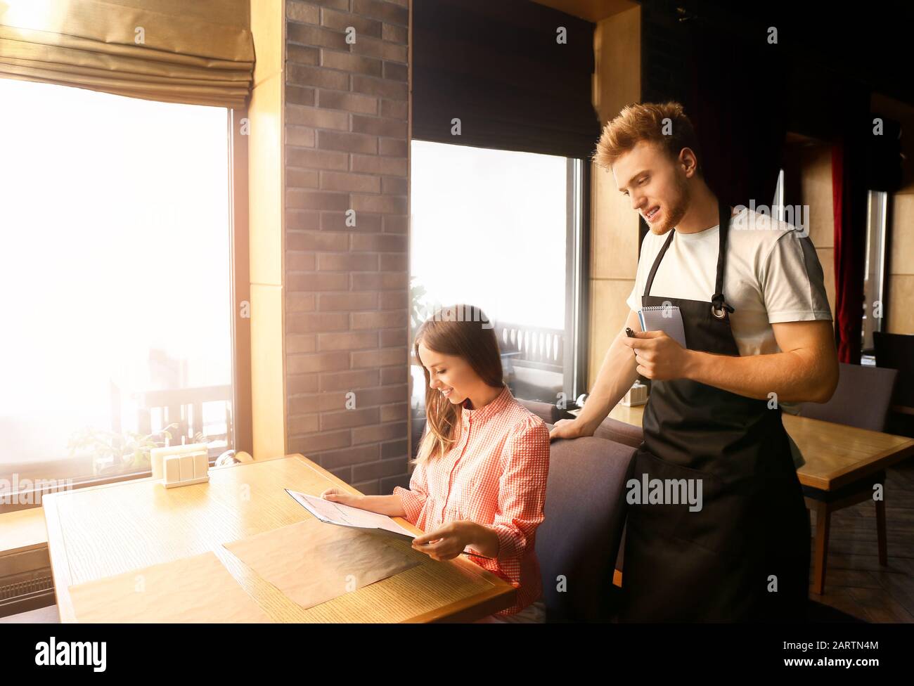 Waiter serving client in restaurant Stock Photo - Alamy