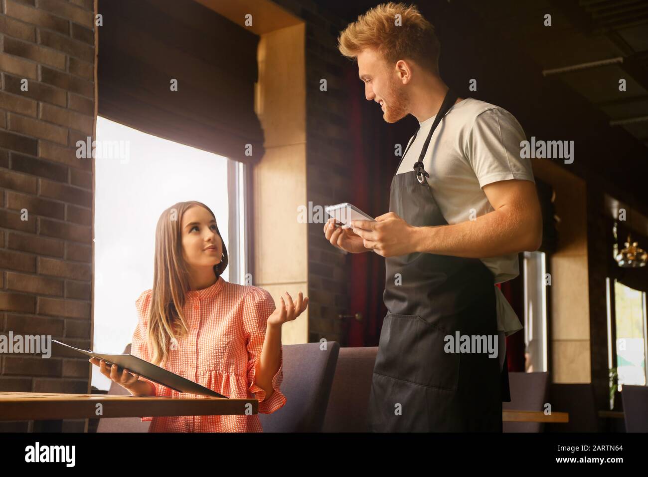 Waiter serving client in restaurant Stock Photo - Alamy