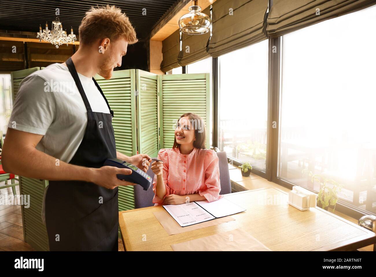Woman paying bill in restaurant through terminal Stock Photo - Alamy