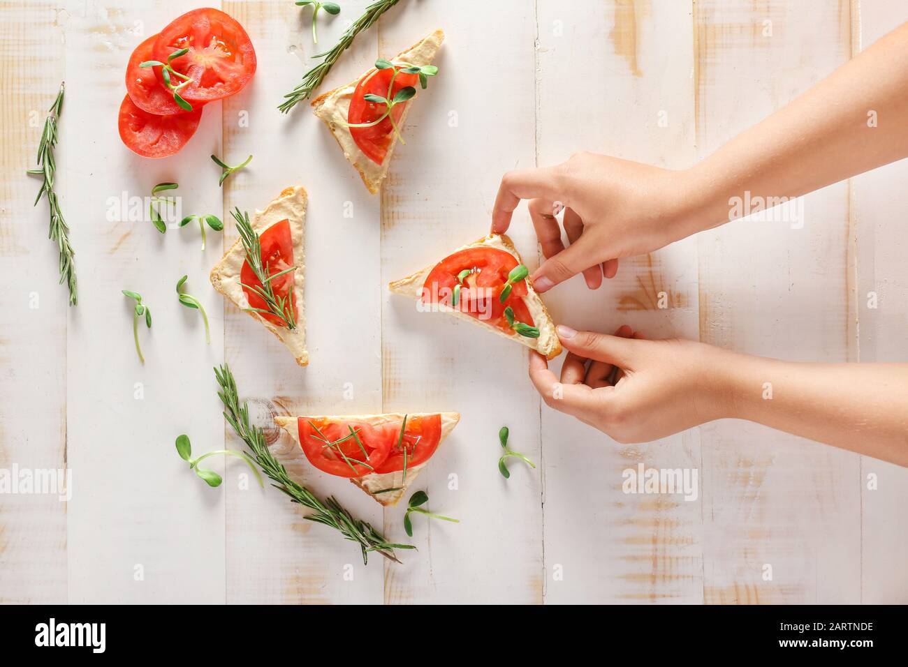 Female hands with tasty sandwiches on white wooden background Stock ...