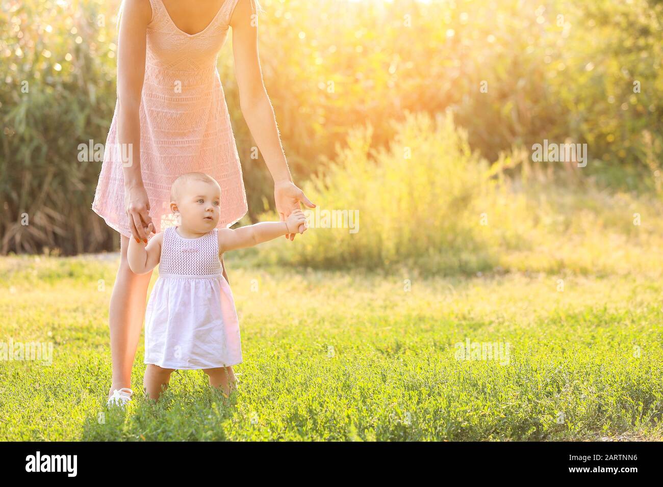 Mother teaching her little baby to walk outdoors Stock Photo - Alamy
