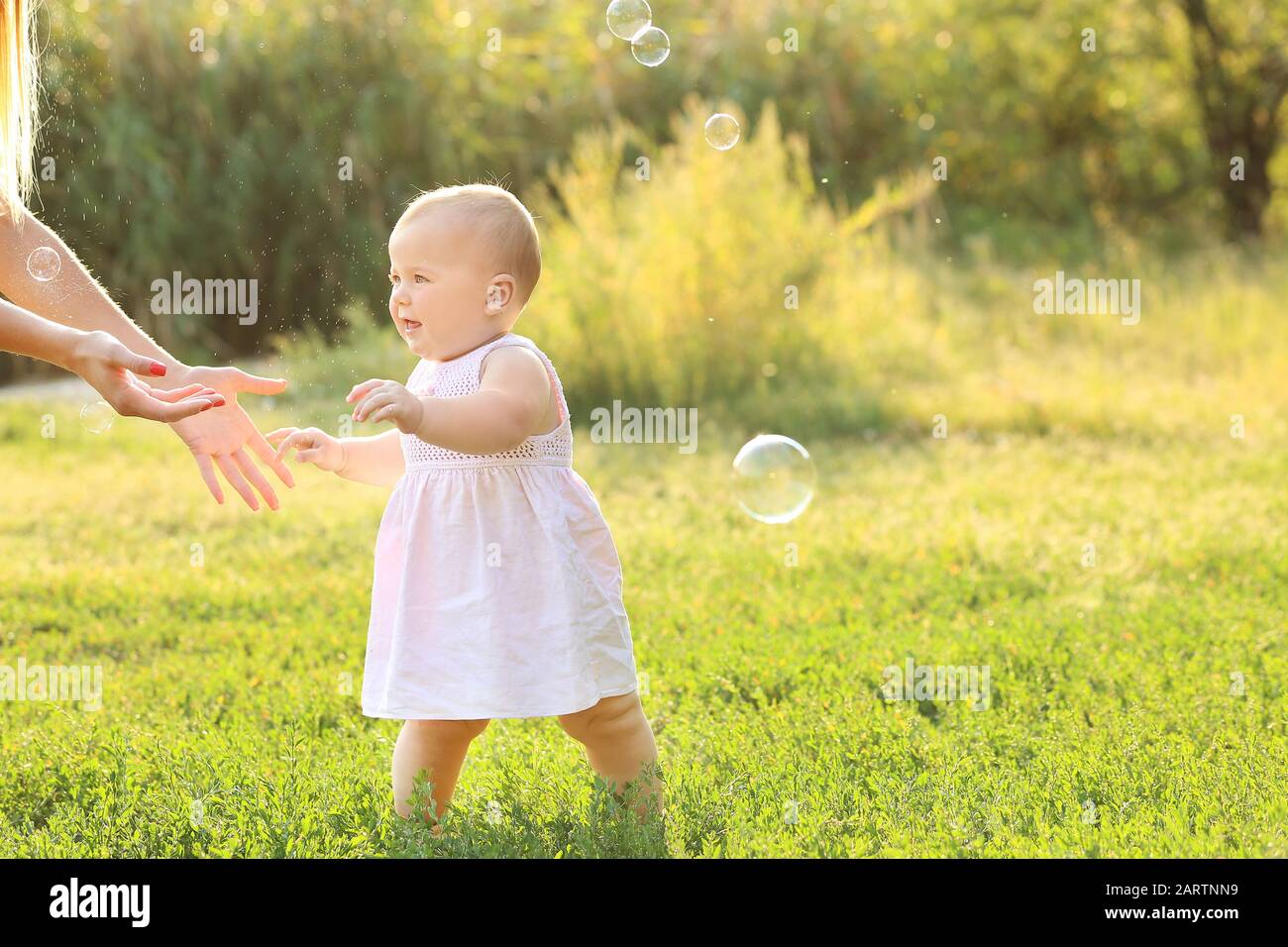 Mother teaching her little baby to walk outdoors Stock Photo - Alamy